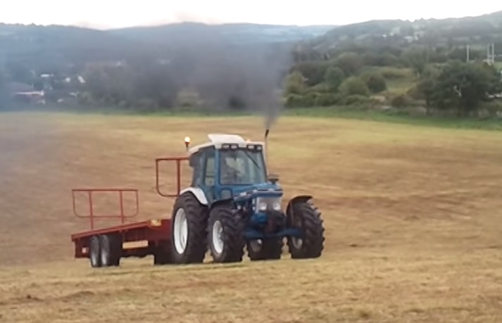 Ford 7810 with straight pipe pulling a 30ft bale trailer up a steep ...