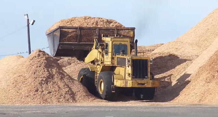 Front end loader working scooping wood chips