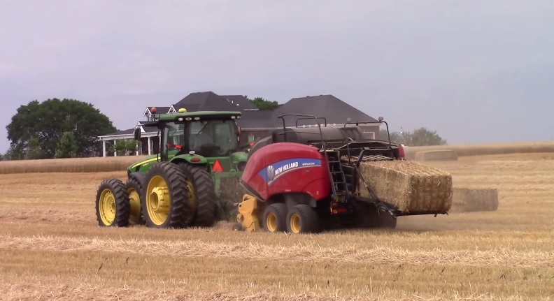 The New Holland Big Baler 340 is powered by a John Deere 8295R tractor ...