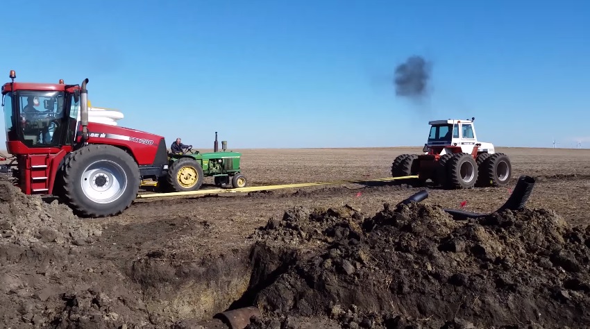 Tractor pulling a tractor pulling a tile plow. -Michelle Adwell-