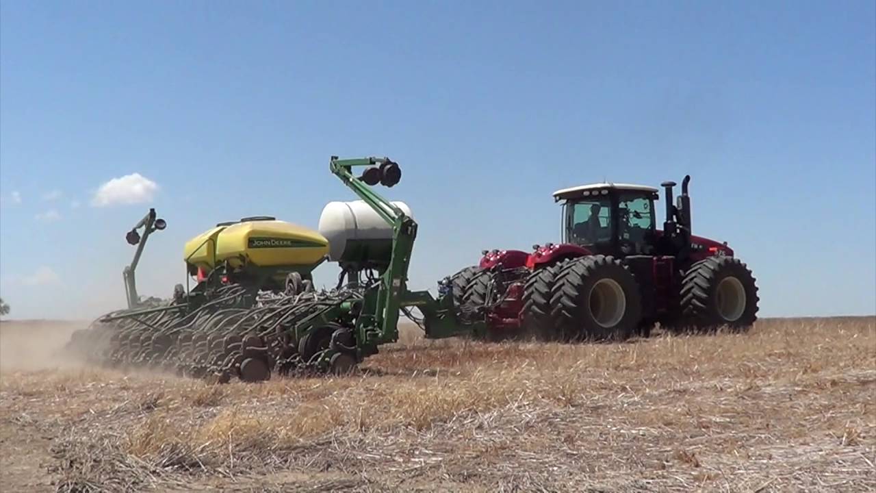 Versatile 575 tractor pulling a John Deere planter planting milo no ...